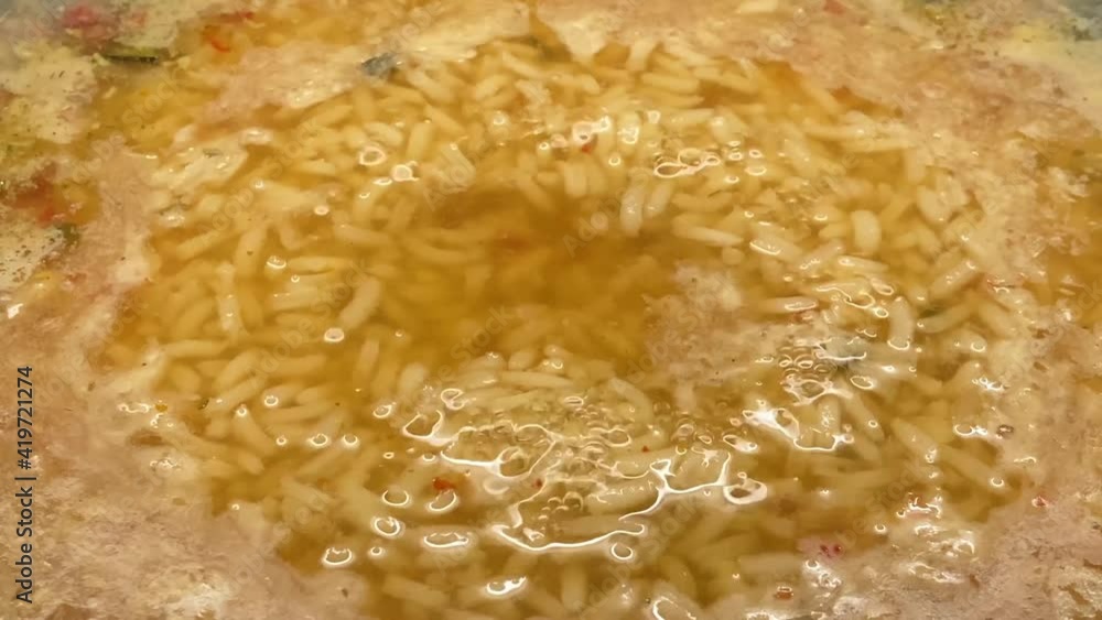 The camera watches the rice dish boil and boil and stop boiling again ...