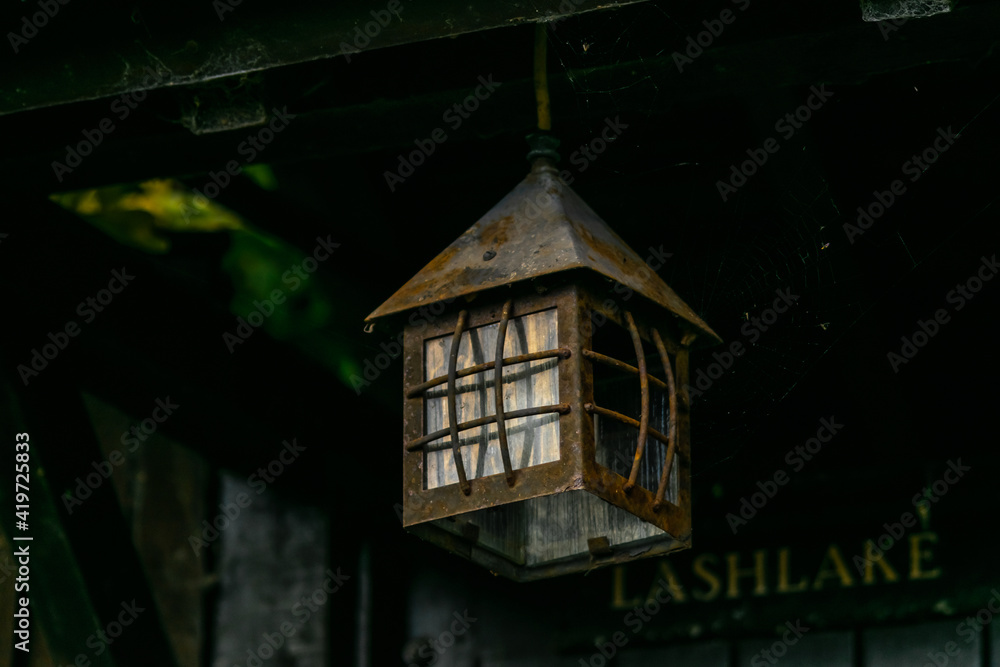 Single vintage lantern hanging over the door to old english cottage ...