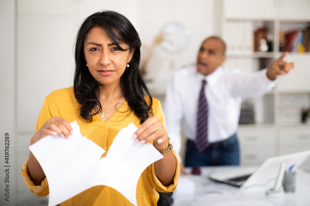 Upset female office employee tearing piece of paper, trying to calm ...