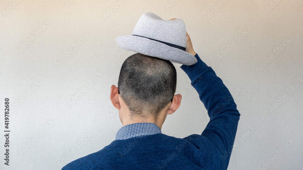 The back view of a Japanese man who takes off his hat and greets him ...