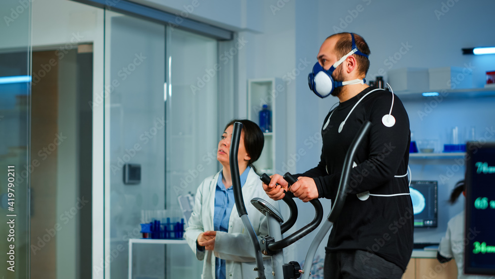 Medical researcher talking with sportsman and showing EKG scan on ...