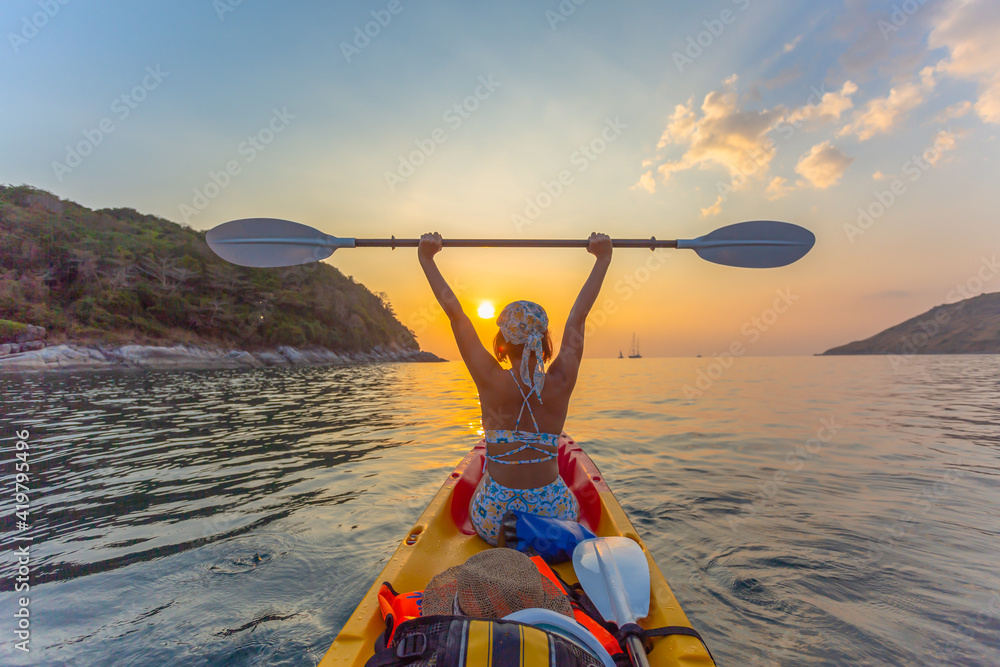 A female tourist wearing a bikini sits on a canoe. .And raise a canoe ...