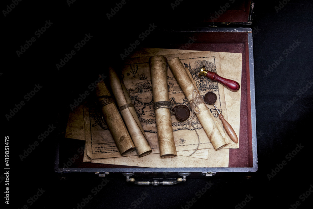 In the old case there are ancient scrolls with a wax seal, an old map ...