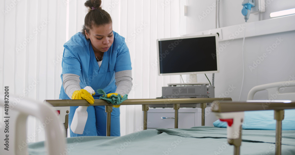 Afro-american nurse cleaning hospital bed with detergent Stock Photo ...
