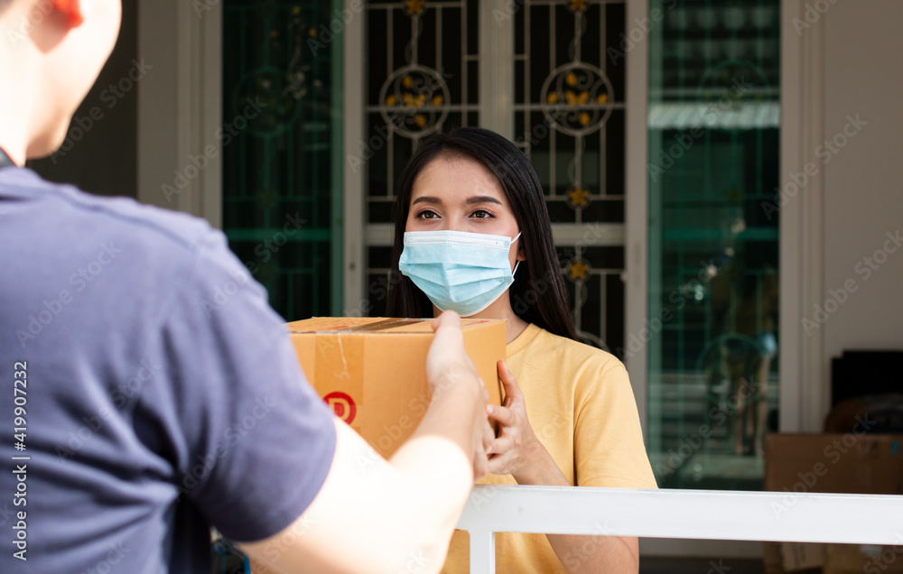 Young woman accepting a delivery of boxes from delivery services ...