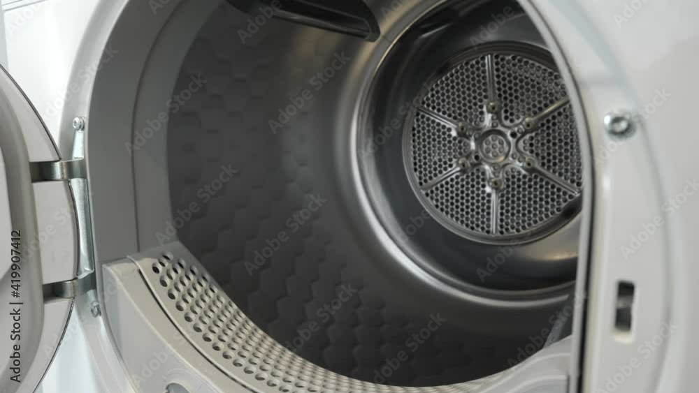 The camera slowly moves along the open washing machine and shows its ...