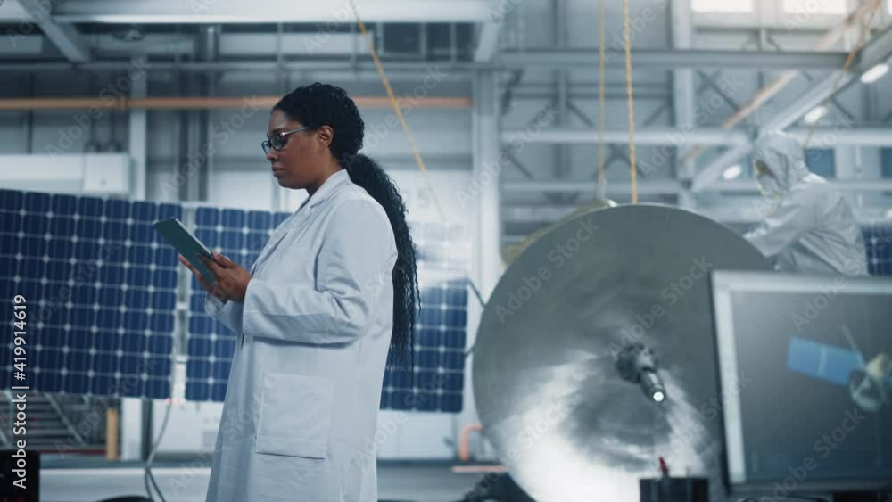 Female Engineer Uses Tablet Computer while Working on Satellite ...