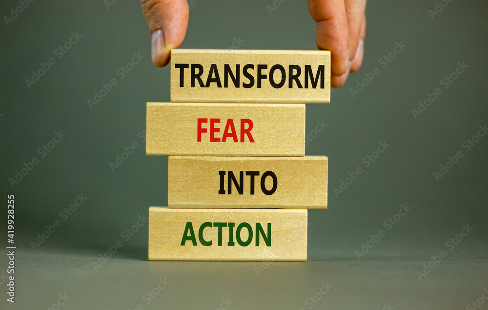 Transform fear into action symbol. Businessman holds wooden blocks with ...