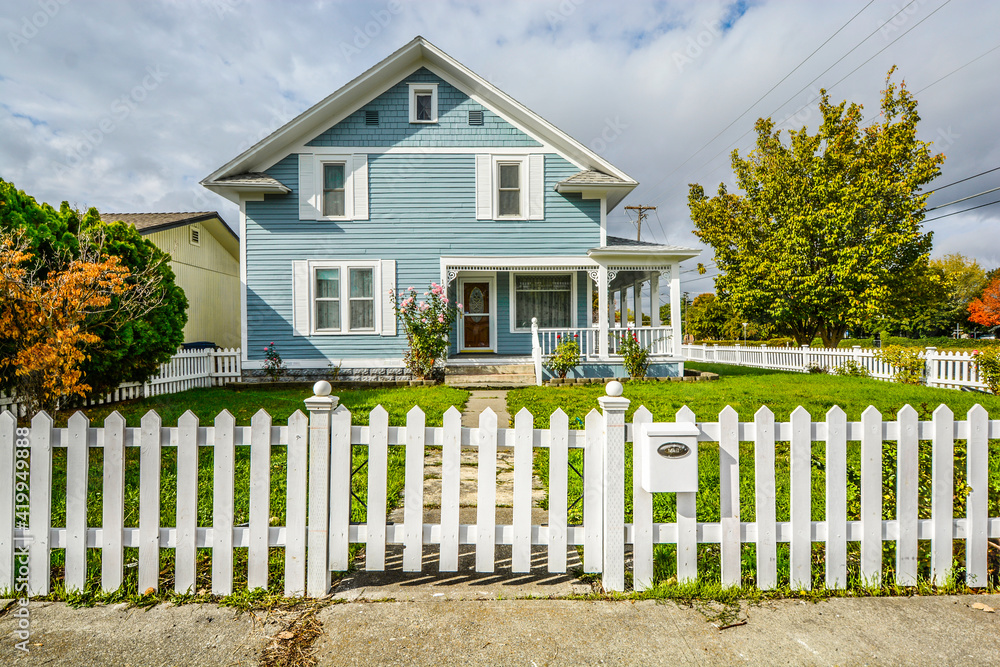 Front view of a Victorian style home with a white picket fence ...