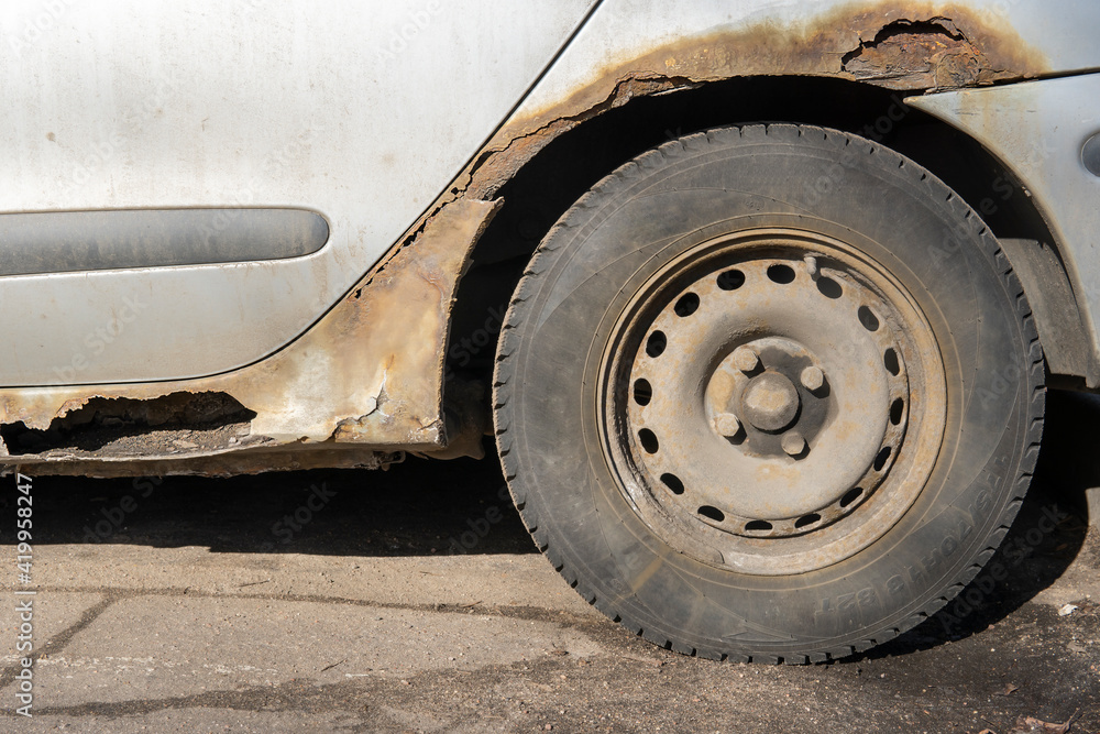 Sheet metal corrosion over wheel of old white car. Rusty messy surface ...