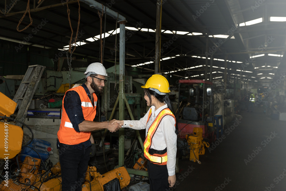 Young mechanical trainee with safety uniform and hardhat works together ...
