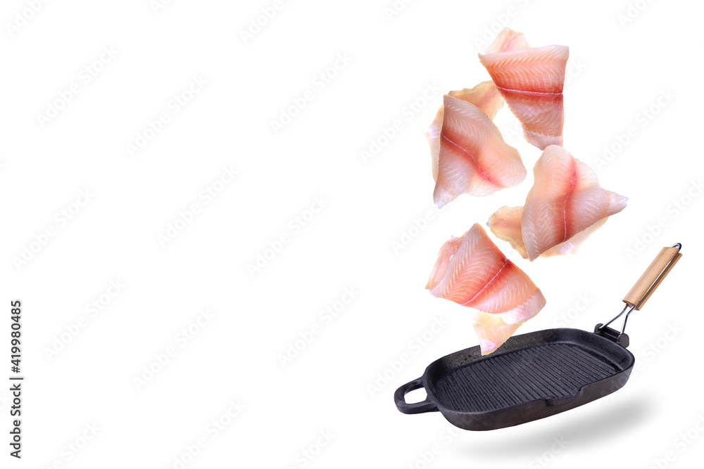 A steak of flying fish falls into the pan. The effect of flying motion ...