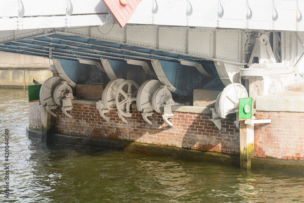 Mechanism of drawbridge across river. Bottom view of gears and lift ...
