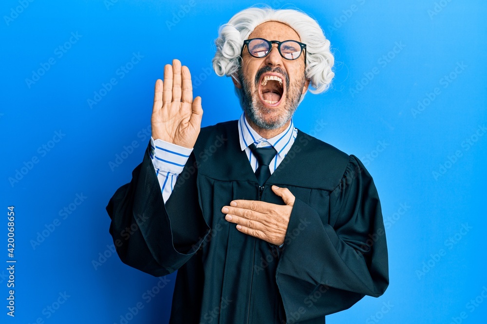 Middle age hispanic man using gavel angry and mad screaming frustrated ...