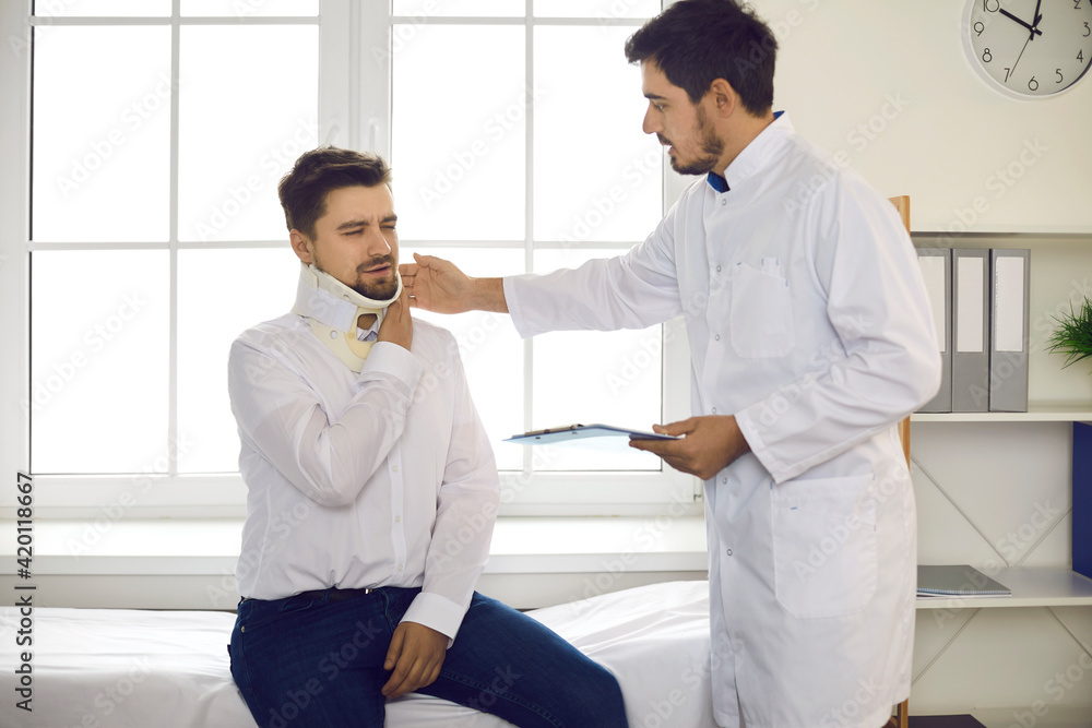 Young man with neck injury telling doctor about his troubles with ...