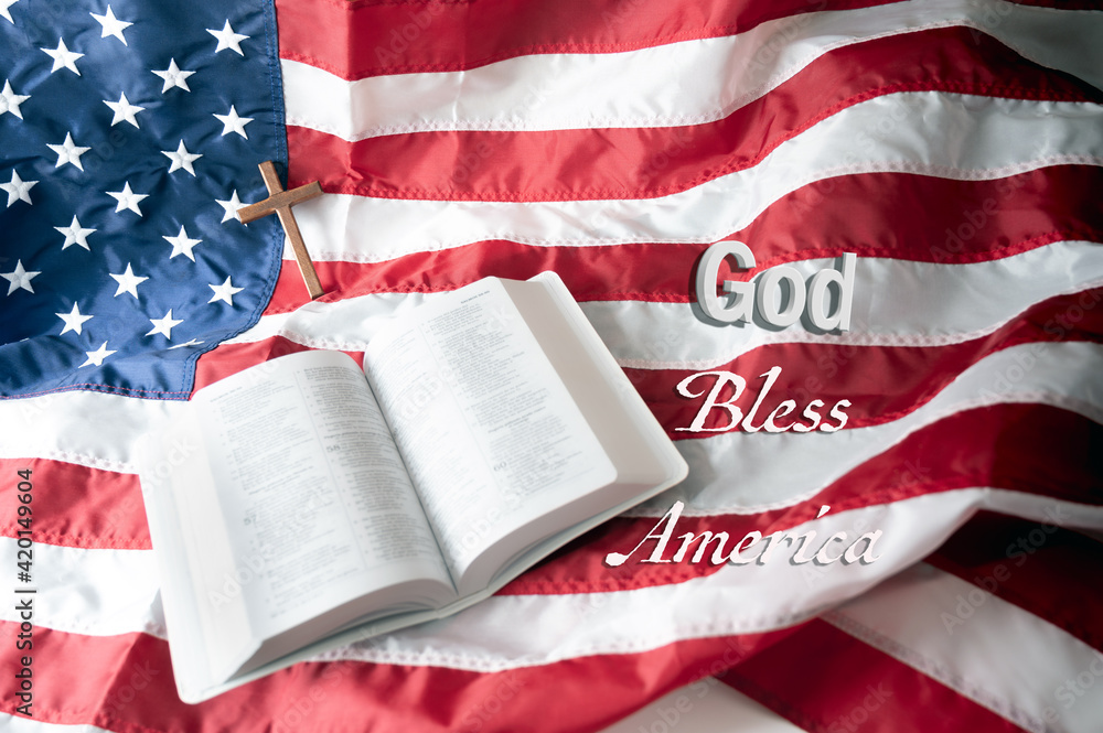 Open Holy bible and Wooden cross over American flag background. God ...