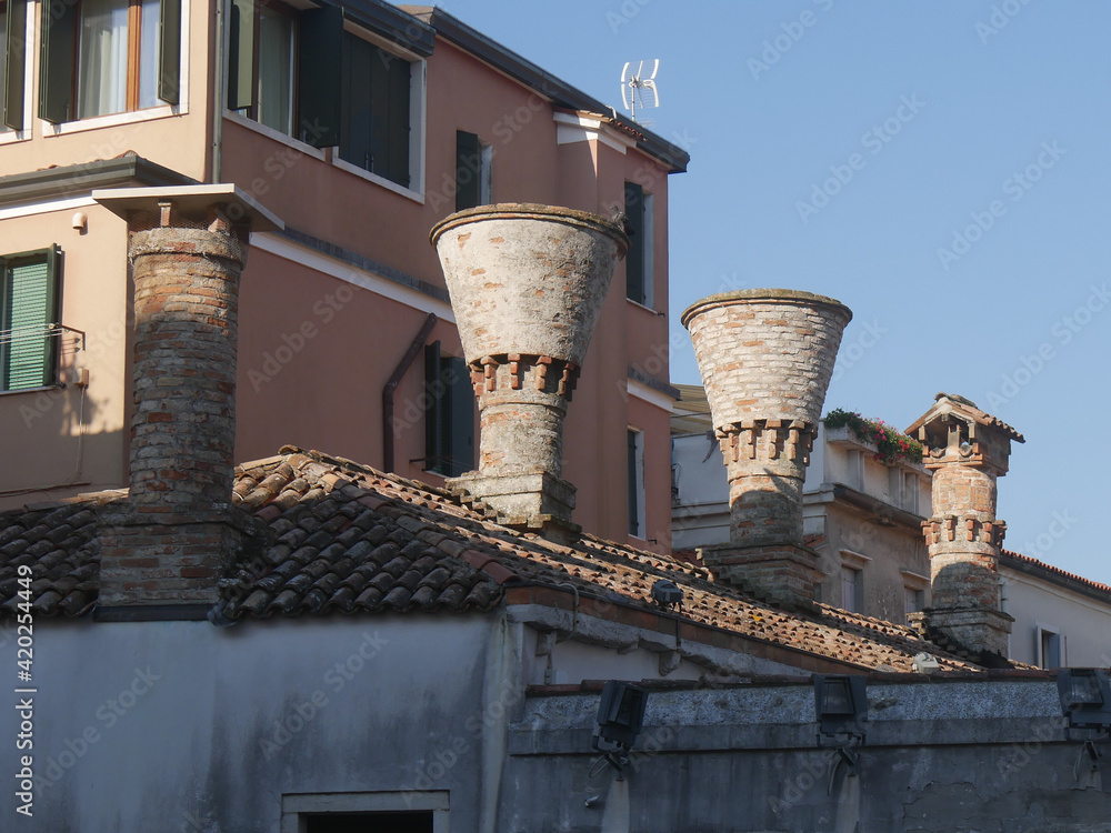 Chioggia, typical ancient chimney on the roof of the building along ...