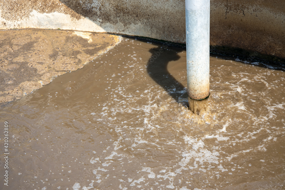 Sewage from drainpipe factory flowing to water treatment tank of waste ...