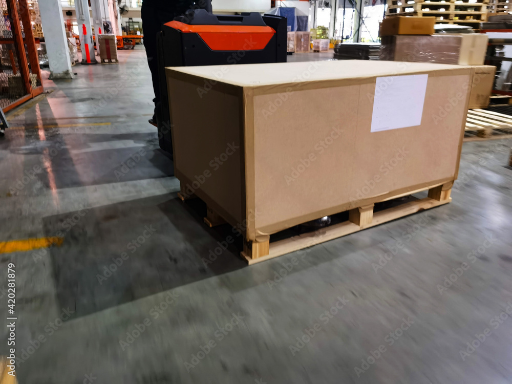 Worker driving forklift loading shipment carton boxes goods on wooden ...