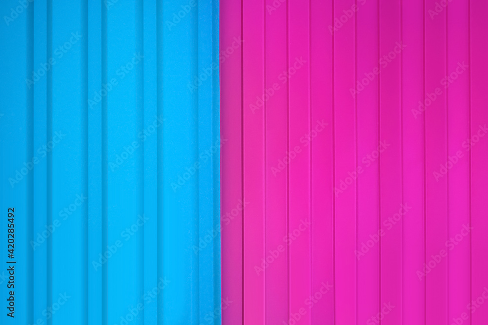 Blue and pink metal fence made of corrugated steel sheet with vertical ...