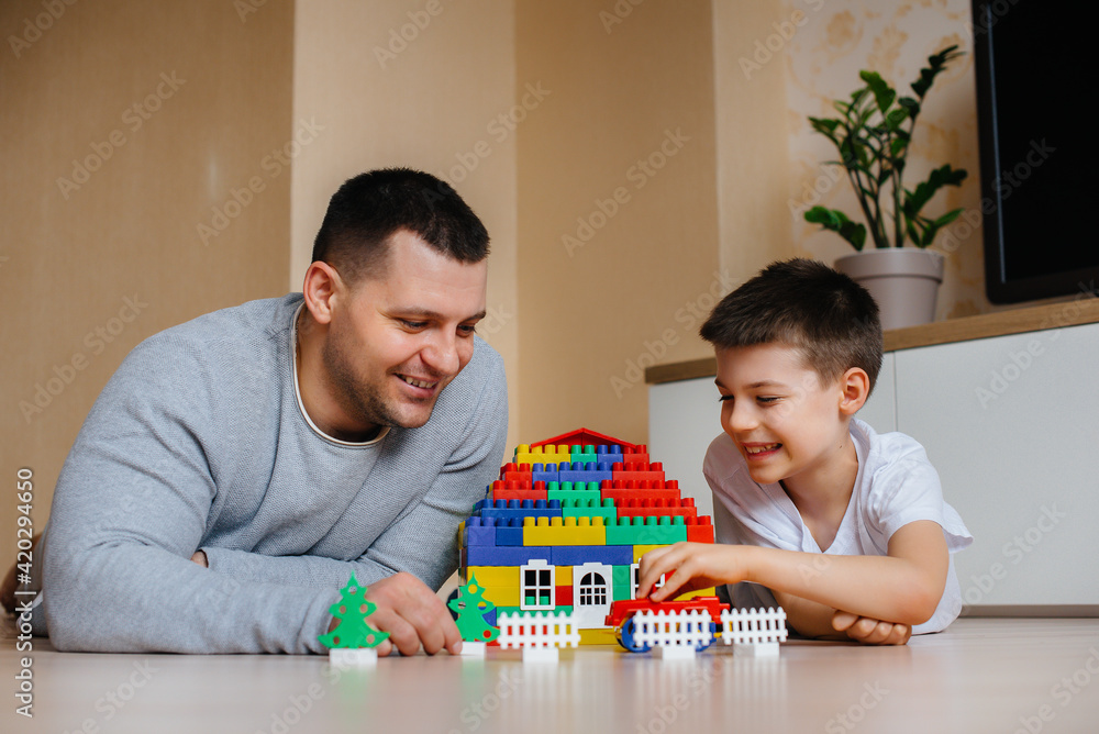 A little boy together with his father is played by a constructor and ...