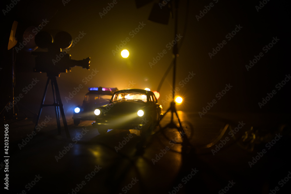 Action movie concept. Police cars and miniature movie set on dark toned ...