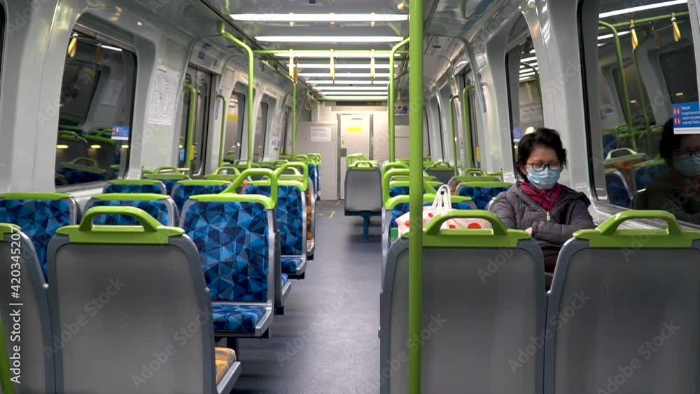 A woman in a mask rides an empty train at the height of the global ...