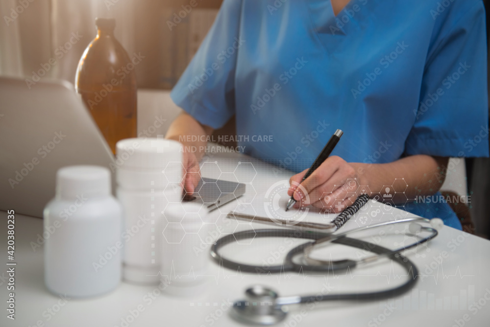 Doctor sitting at table and writing on a document report in hospital ...