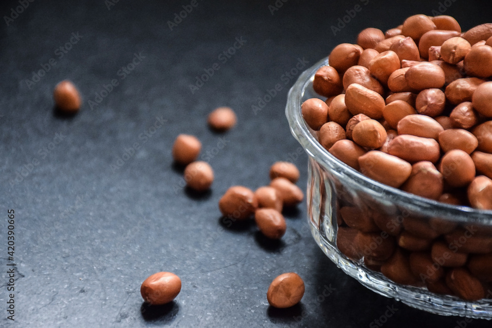 Stock photo of a brown color raw peanuts in transparent glass bowl ...
