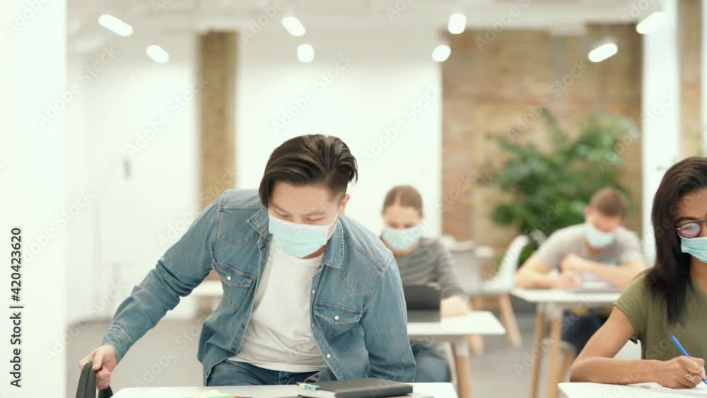 Studying time. Male student coming to a classroom with laptop and ...