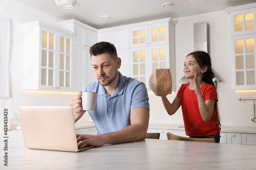 Cute little girl popping paper bag behind father's back while he ...