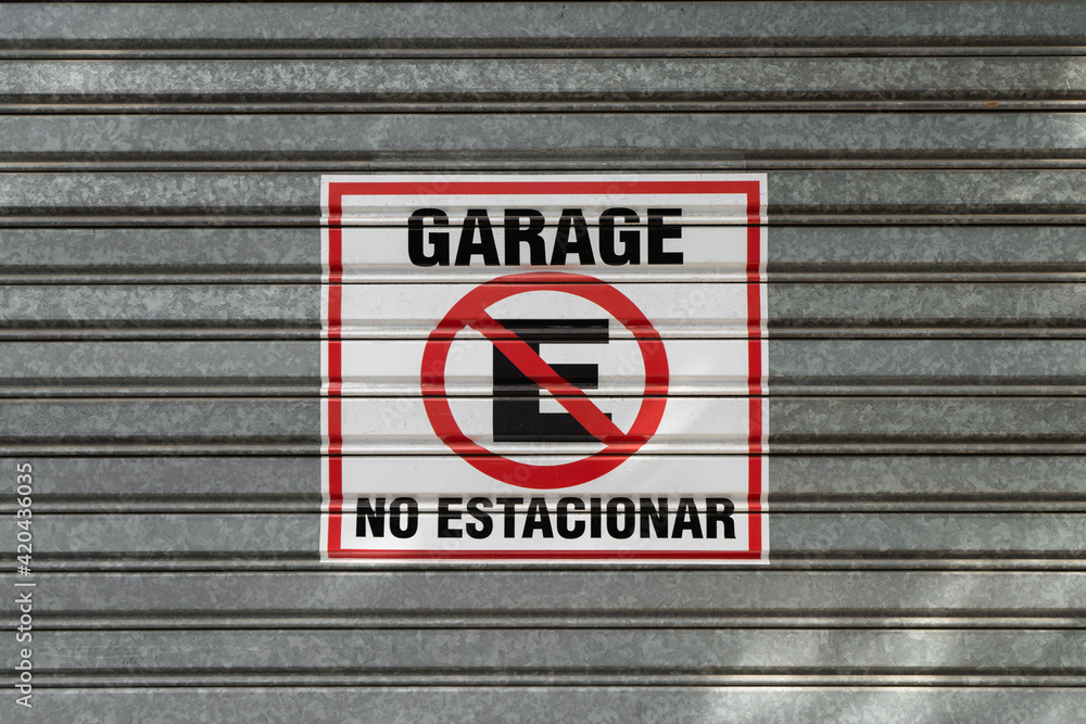 No parking sign at a garage entrance. Written in Spanish "Garage - No ...