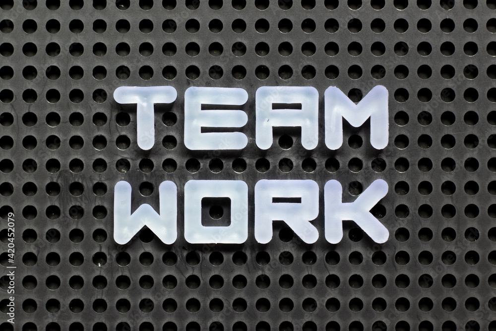 White color letter in word teamwork on black pegboard background Stock ...