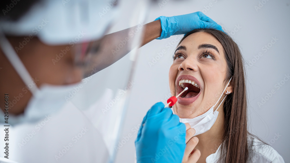 Female caucasian doctor holding a swab collection stick, nasal and oral ...
