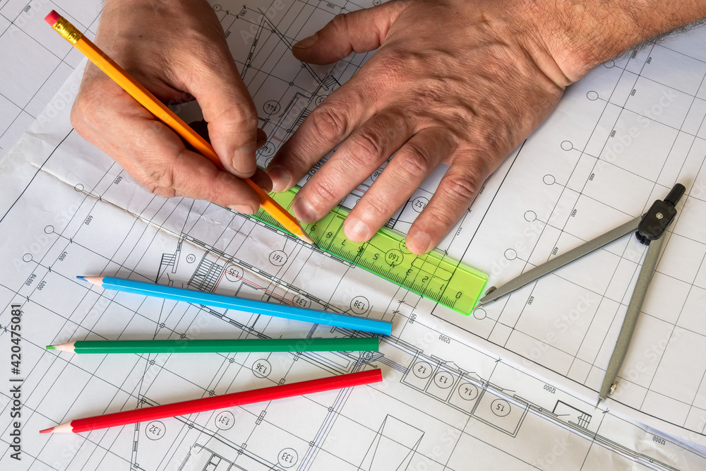 The designer makes a drawing of the building with a graphite pencil ...