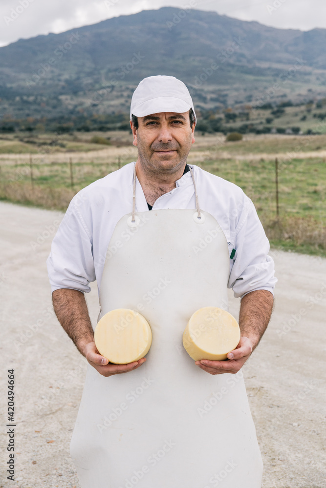 Cheesemaker posing on rural background Stock Photo | Adobe Stock