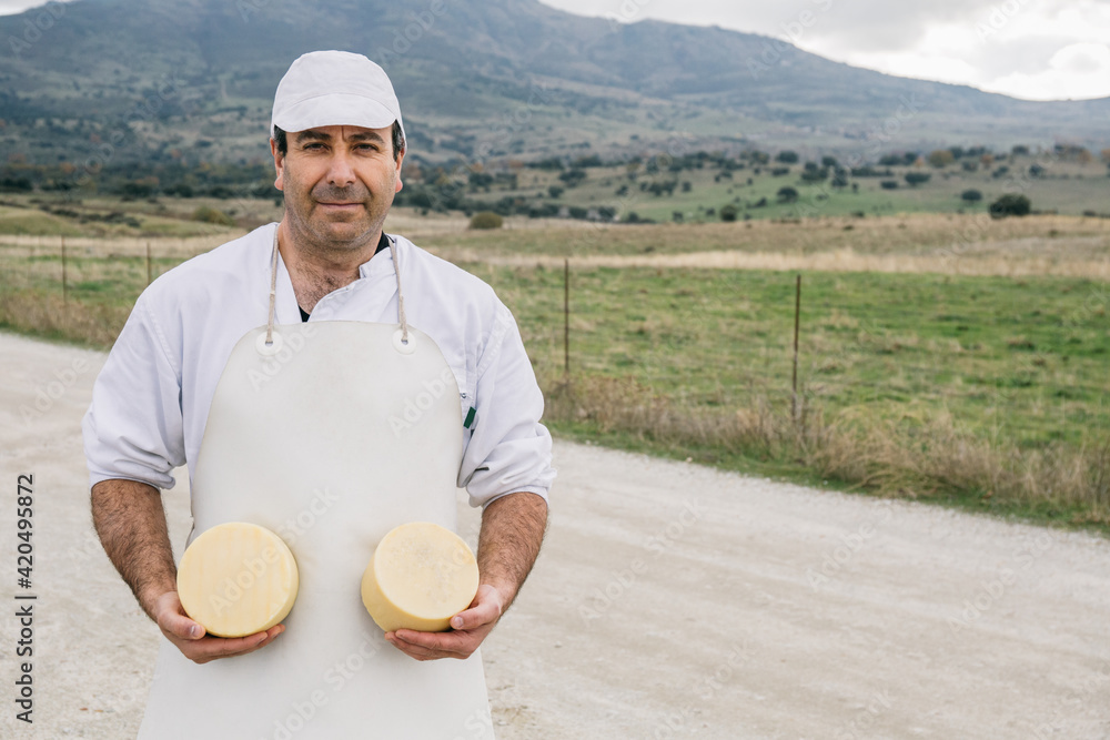 Cheesemaker posing on rural background Stock Photo | Adobe Stock