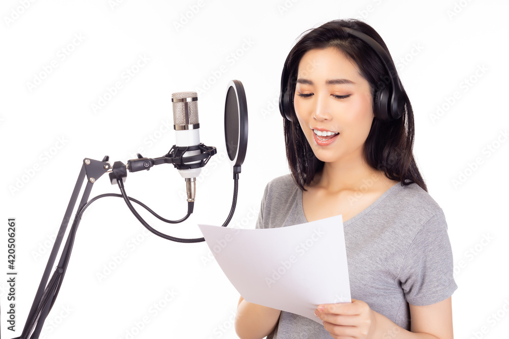Singer woman singing song by reading note on paper in recording studio ...