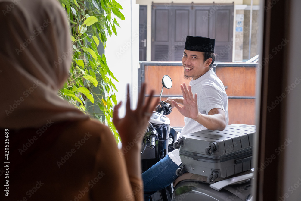 portrait of muslim asian husband waving goodbye to his wife before ...
