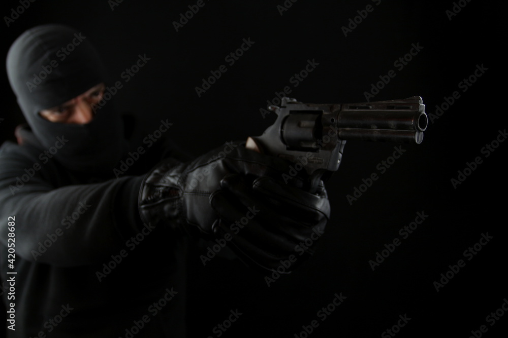 Criminal man with black mask holding pistol, standing shooting with a ...