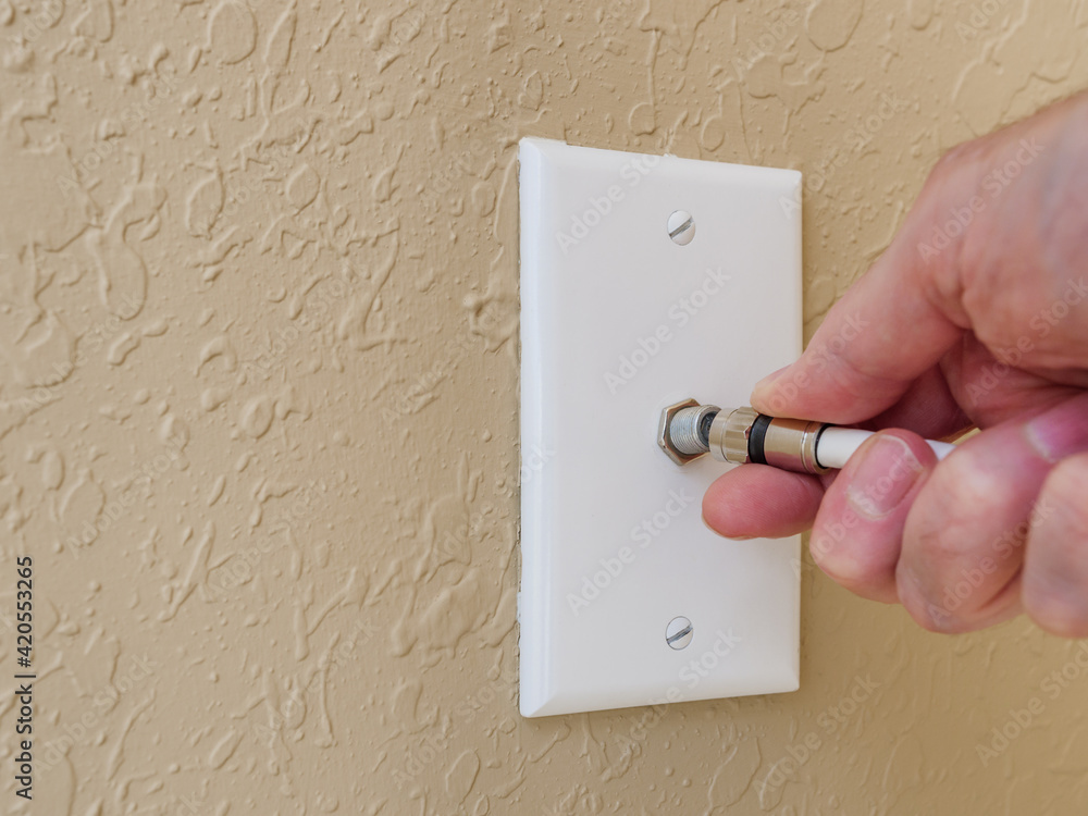 Photo Male electrician connecting coax cable antenna wire to wall ...