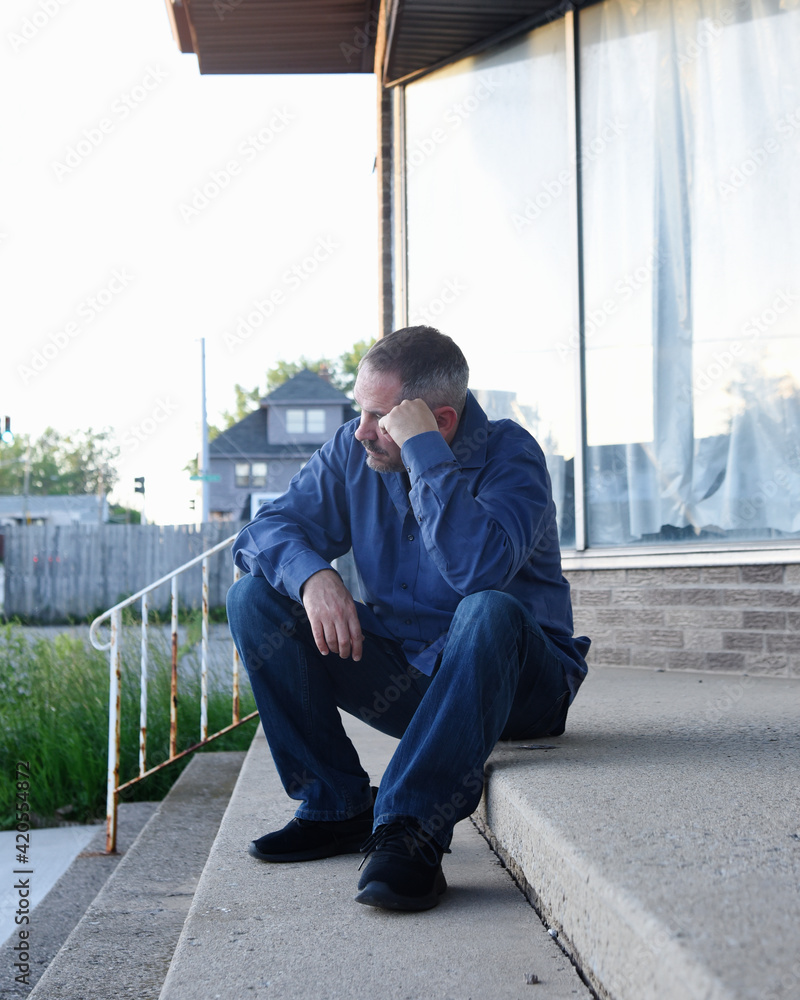 Sad Man Sitting on Steps Outside Closed Store Stock Photo | Adobe Stock