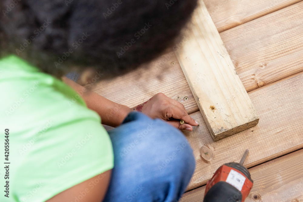 Tween girl using power tools to help build an outdoor deck Stock Photo ...