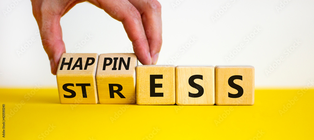 Happiness instead of stress. Businessman turns a cube and changes the ...