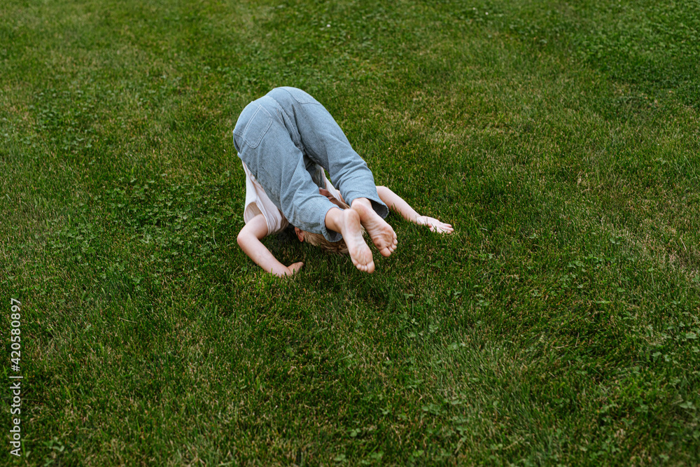 little boy rolling over in the garden Stock Photo | Adobe Stock