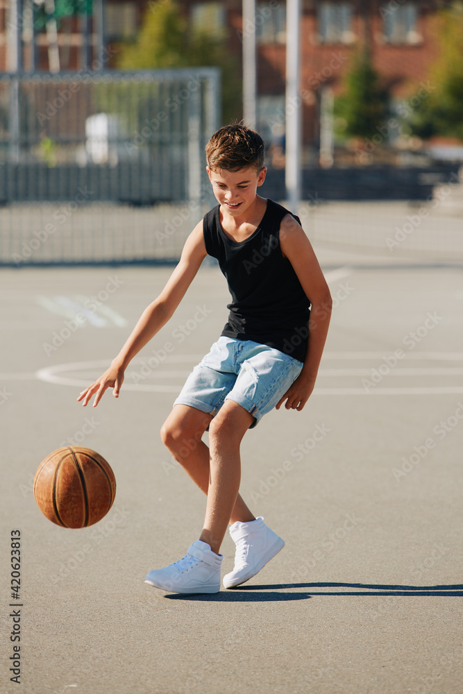 Young boy dribbling a basketball Stock Photo | Adobe Stock