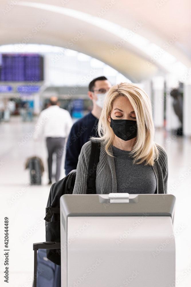 Travel: Mature Woman Uses Self Service Airline Check-In Kiosk Stock ...