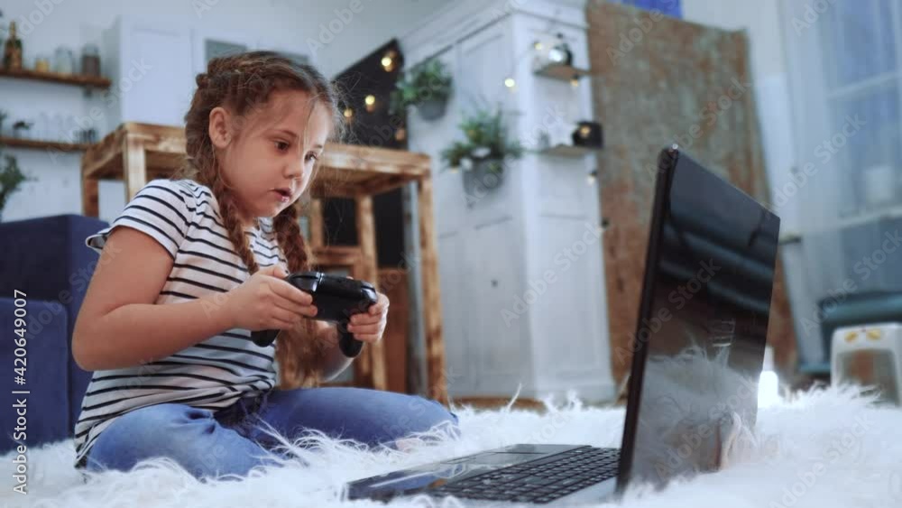 Vidéo Stock little girl playing video game on gamepad. kid dream stay ...