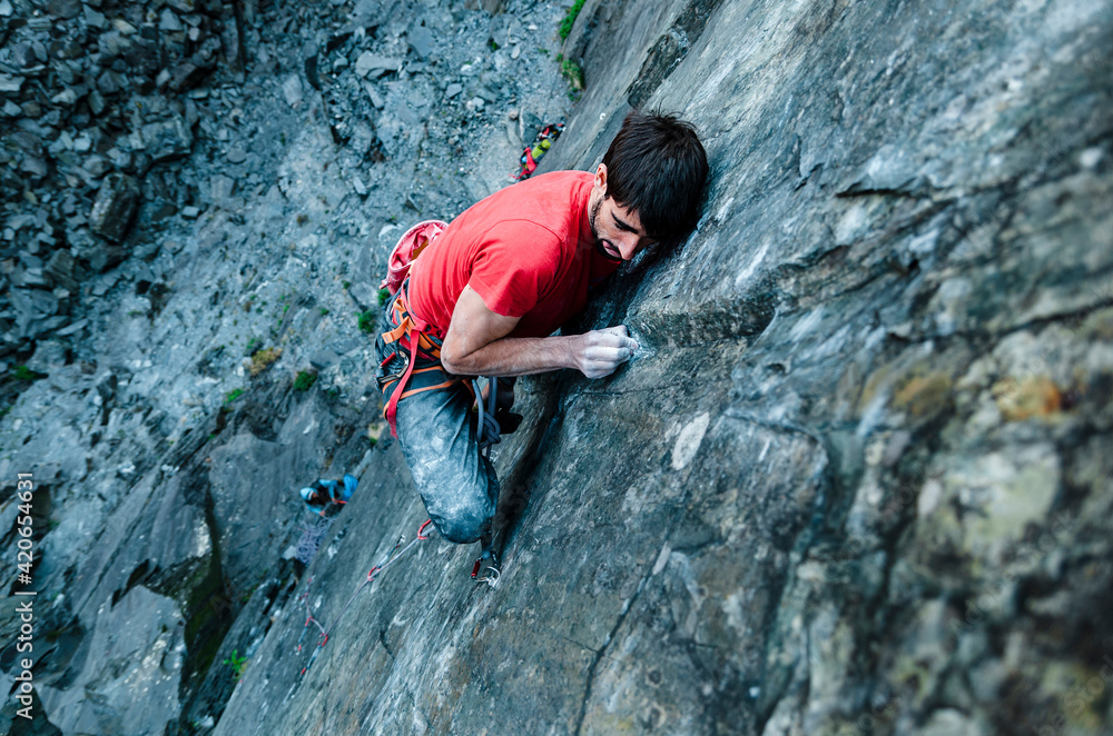 Climber grabbing a small ledge in quarry wall Stock Photo | Adobe Stock
