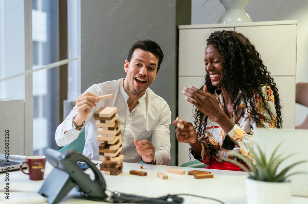 Cheerful colleagues playing Jenga game at workplace Stock Photo | Adobe ...